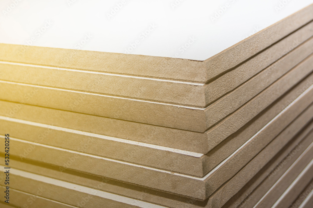 a stack of mdf panels neatly stacked in a cabinetry shop, background ...