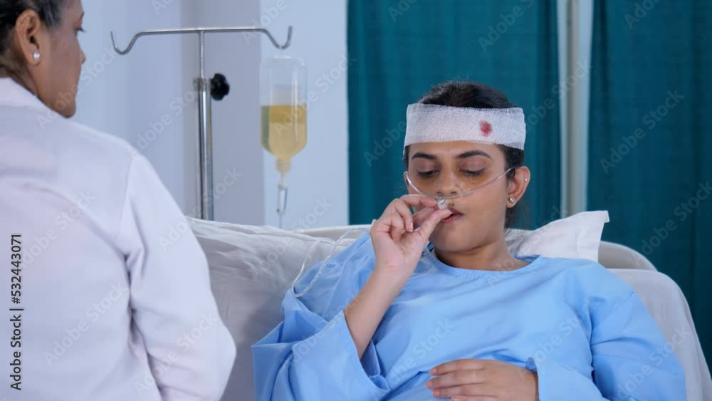 A lady doctor checking body temperature of a female patient with a ...