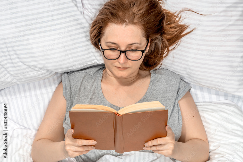 Woman sreading book in bed at home. Deep sleep. Lady with long brown ...