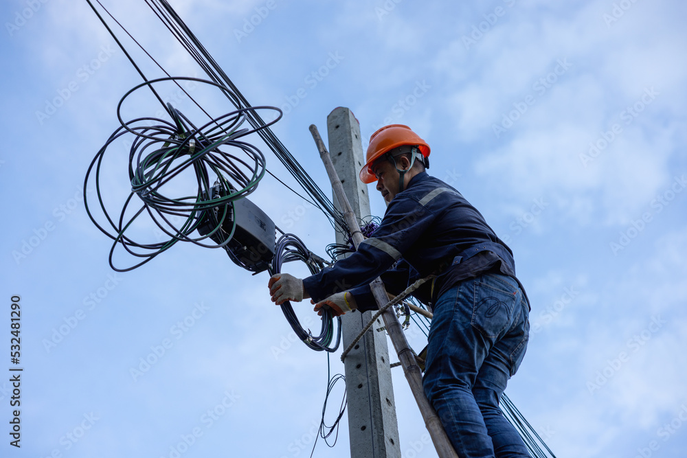 Poster A telecoms worker is shown working from a utility pole ladder ...