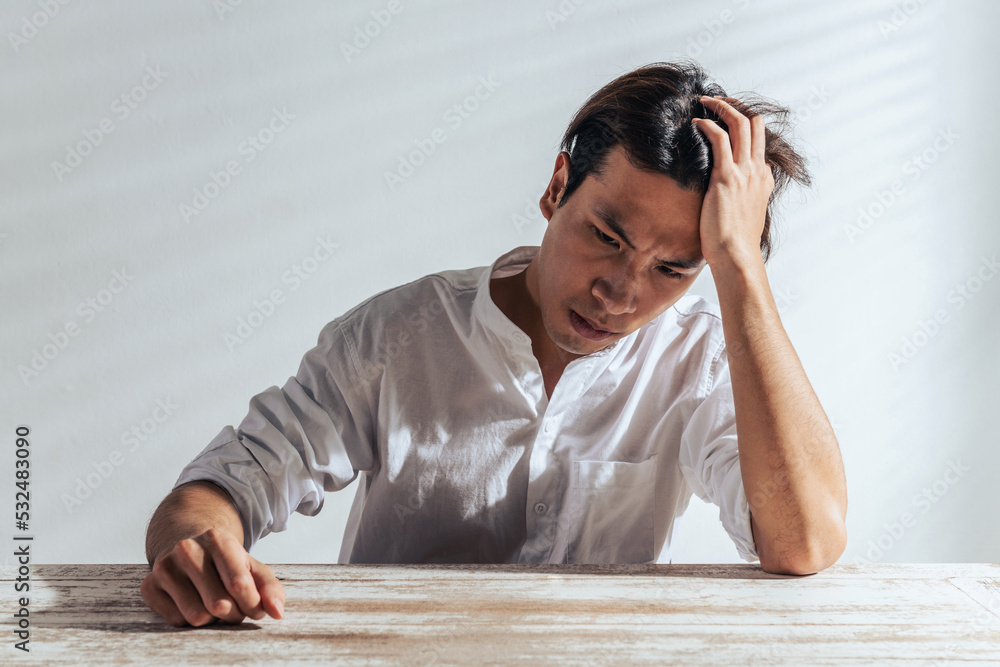 confused asian man overthinking sitting alone. despair indoors home ...