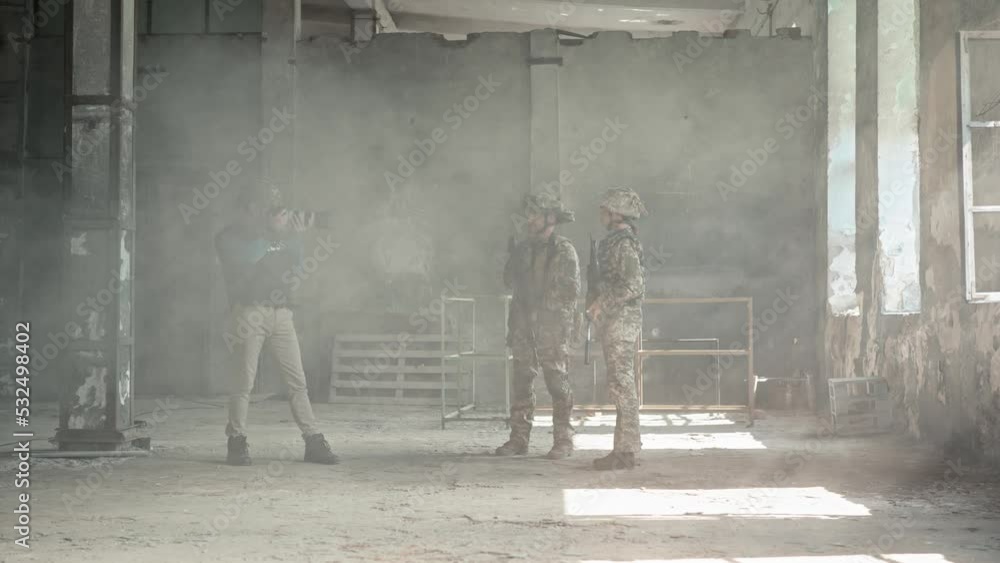 Male photo journalist aking pictures of soldiers in the place of action ...