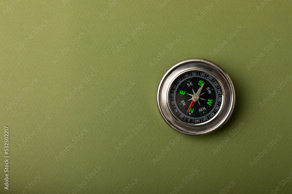 Classic round compass on green texture background. The concept of ...