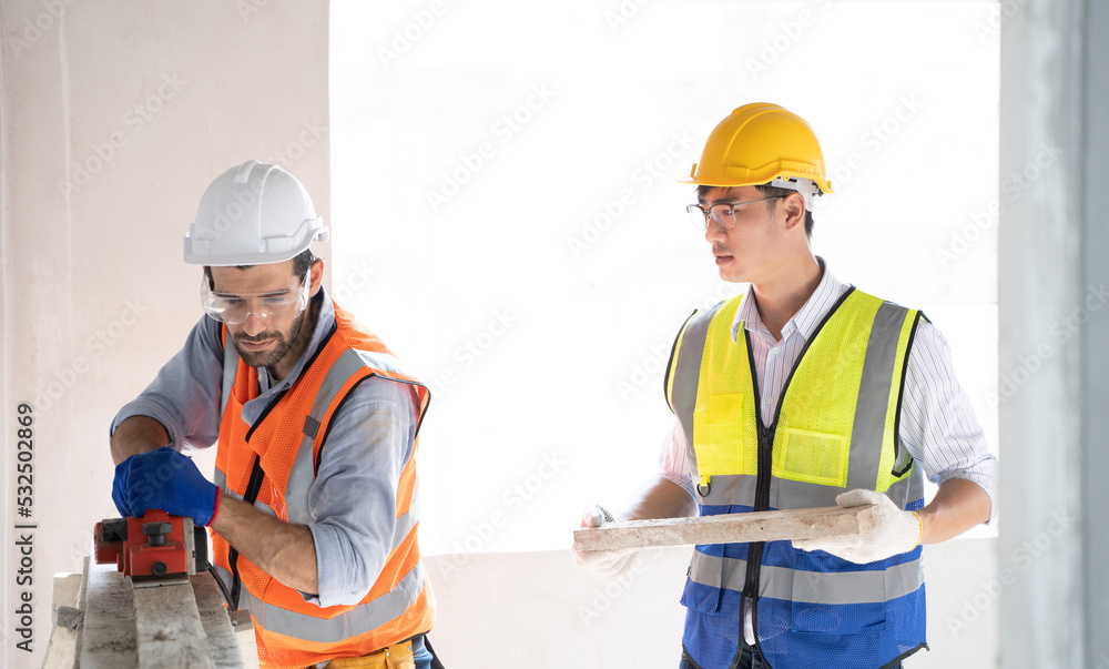 Engineer wearing safety vest controlling machine working with assistant ...