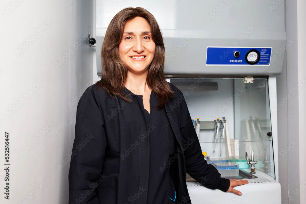 Portrait of a female scientist next to the laminar air flow cabinet in ...