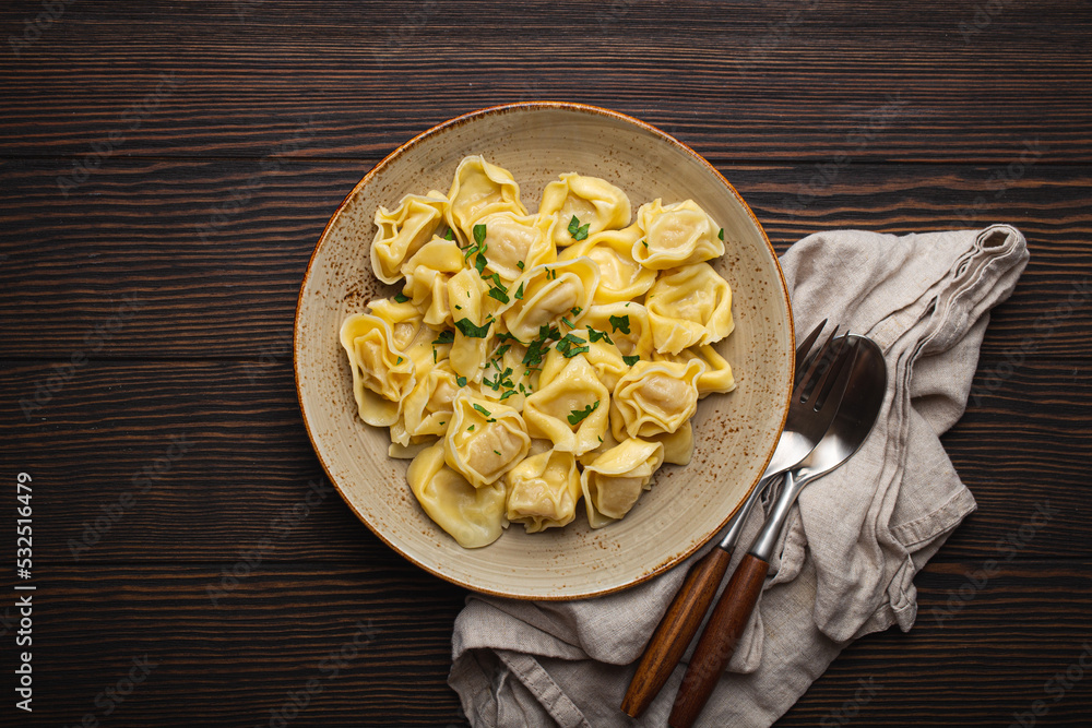 Italian filled tortellini ravioli on ceramic plate top view on dark ...