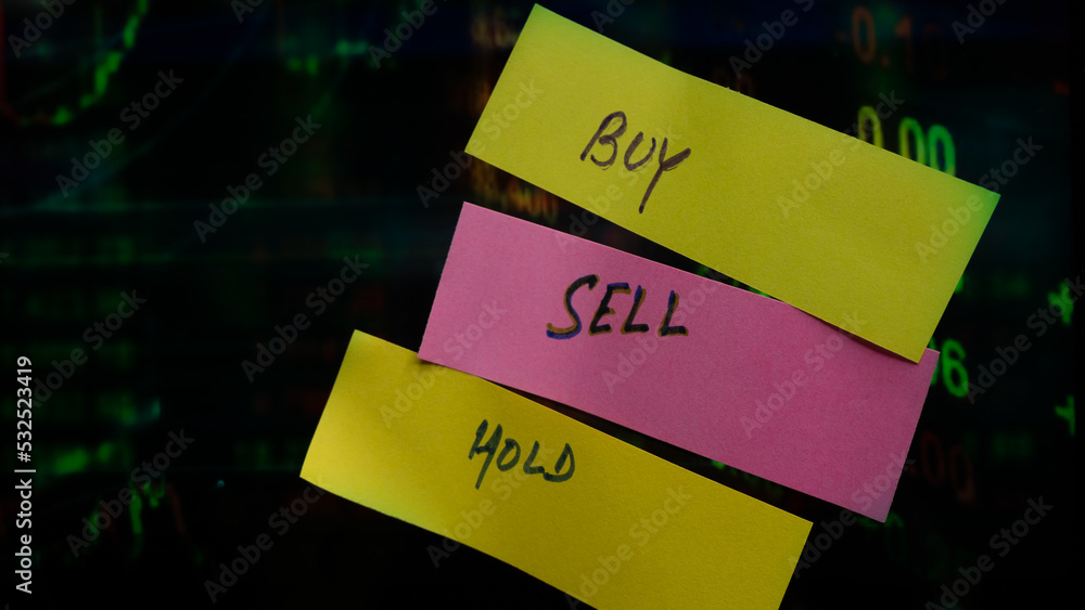 Concept of Buy Sell Hold written on sticky notes attached on share ...