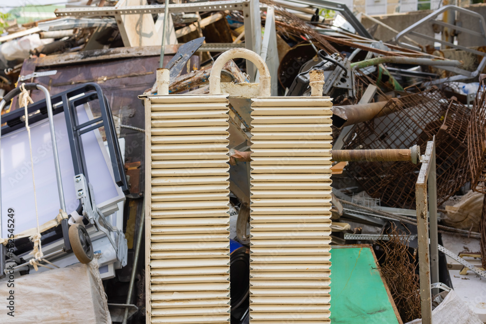 Multi colored cast iron radiators, old heating elements stacked in heap ...