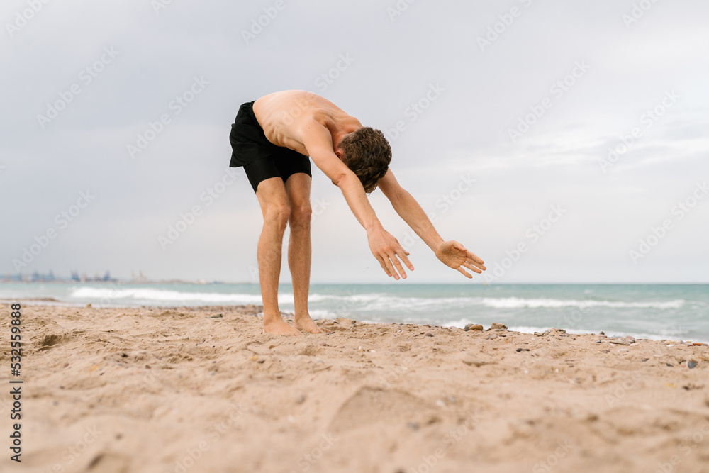 Shirtless male bending forward near sea Stock Photo | Adobe Stock