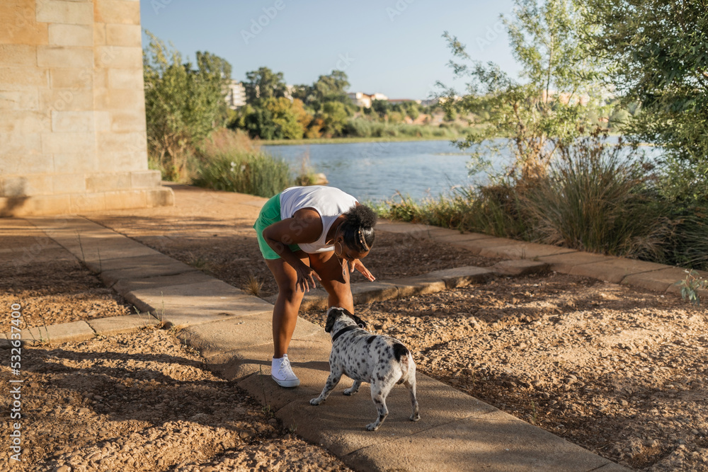 young black woman with her dog under a bridge next to a river Stock ...