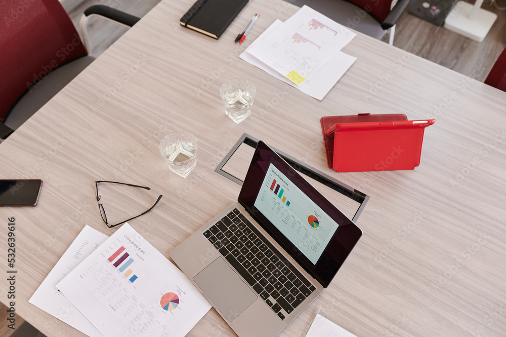 Laptop and paperwork sitting on an office table Stock Photo | Adobe Stock