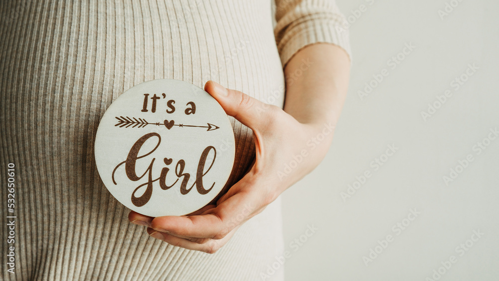 Woman hands touching pregnant belly and holding wooden logo with text ...