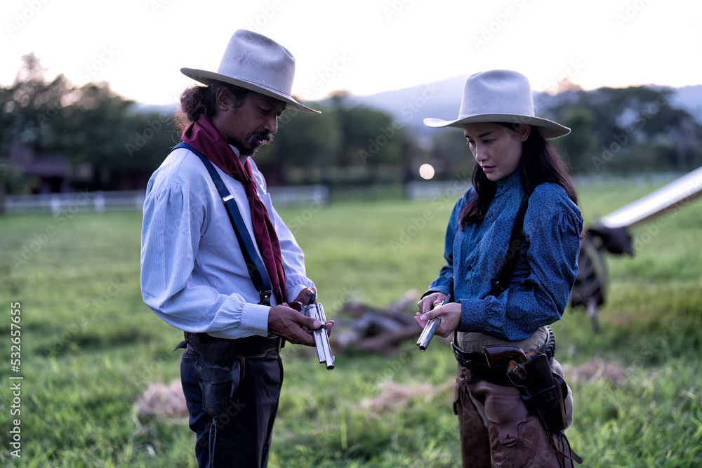 Cowboy man standing at the green land near mountain side teaching cow ...