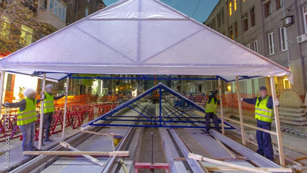 Builders making tent cover over tram rails at the stage of their ...