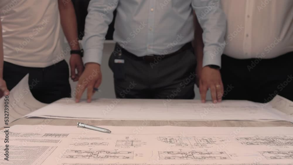 Vidéo Stock Team of professional engineers reveals a huge sheet with ...