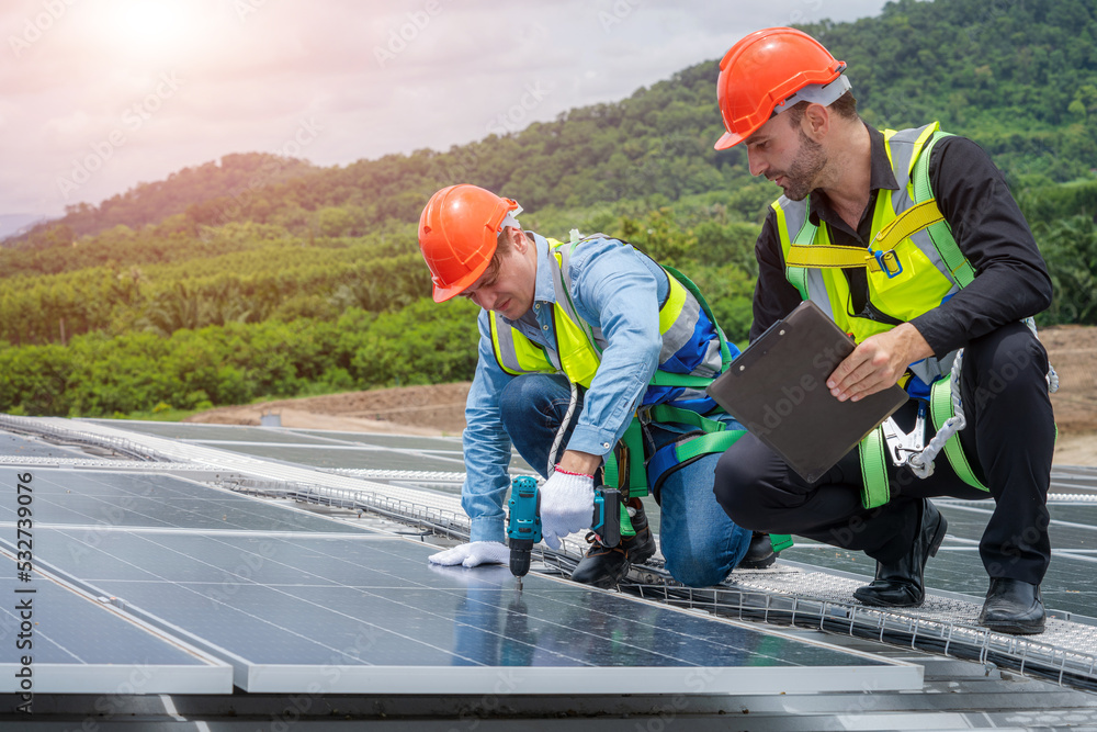 Technician wearing safety harness belt using drill during installing ...