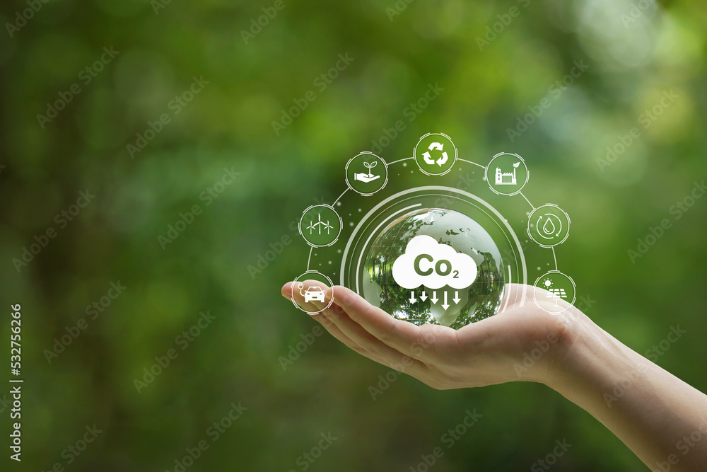 Reduce CO2 emission concept. Hand-holding crystal globe with a CO2 icon ...
