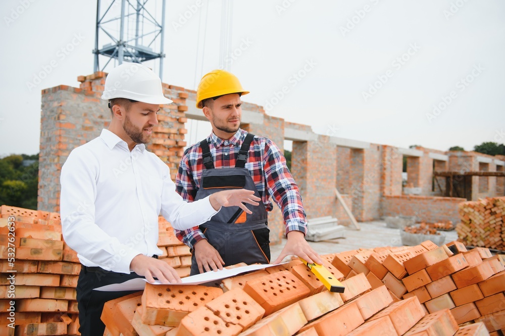 Construction engineers supervising progress of construction project ...