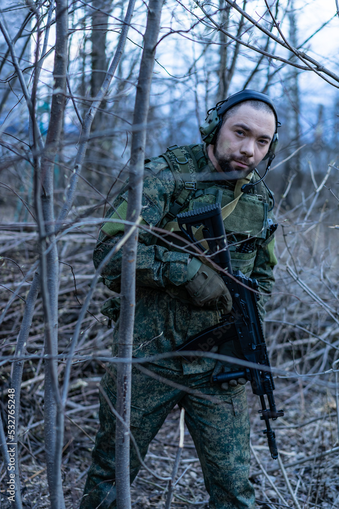 soldier in the forest. a man in military uniform in the branches of ...