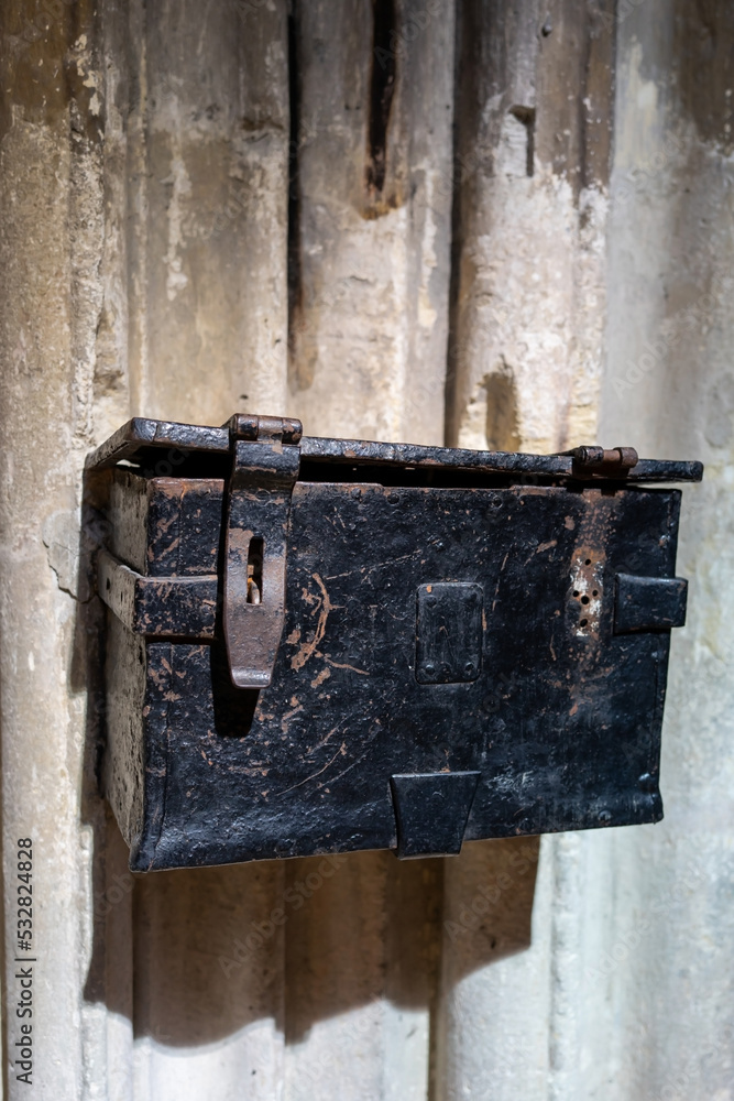 offering in a church. Black, rusty donation box in front of an gray ...