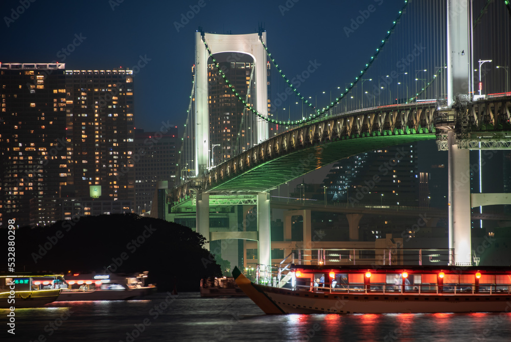 Rainbow bridge at night with yakatabune japanese party boats in tokyo ...