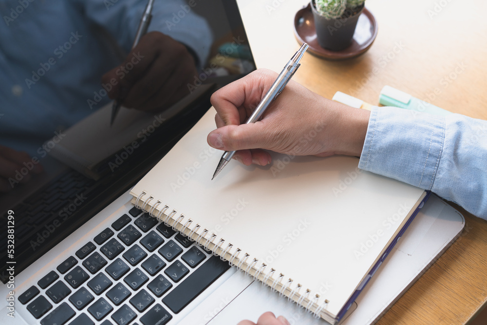 Man makes notes with pen on sheet and on laptop. Good specialist ...