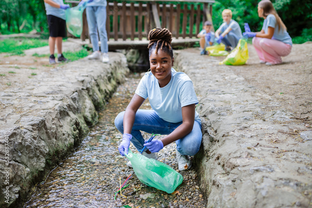 Woman handpicking gathering up garbage plastic straws garbage from the ...