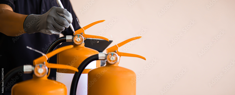 Close up fire extinguisher and firefighter checking pressure gauge ...