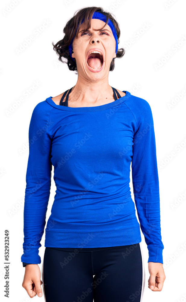 Beautiful young woman with short hair wearing training workout clothes ...