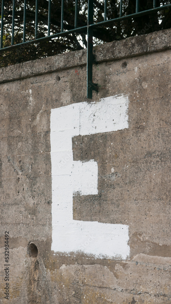 Poster Letra E pintada con pintura blanca en pared de hormigón – Wall ...