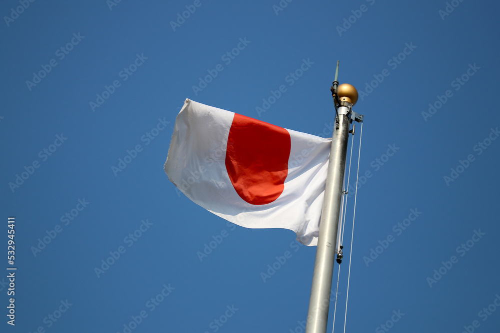 National flag of Japan flaps in the wind. Bright blue sky background ...