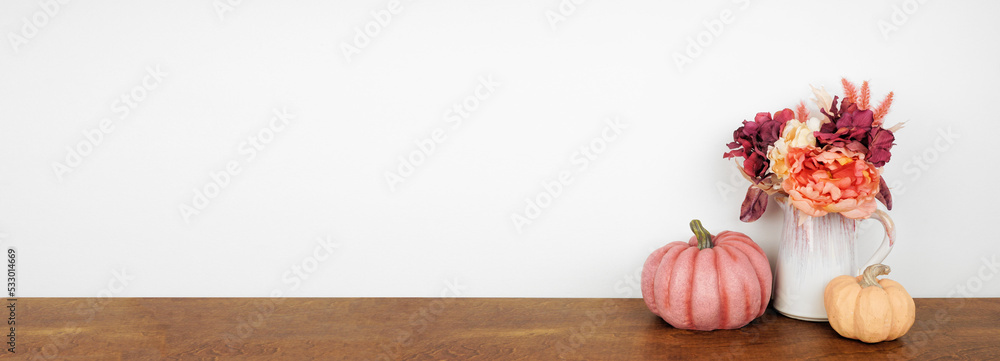 Autumn decor on a wood shelf against a white wall banner background ...