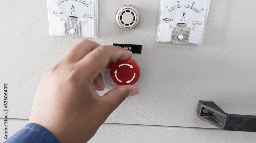 Hand man operating the Emergency stop red button. For emergency ...