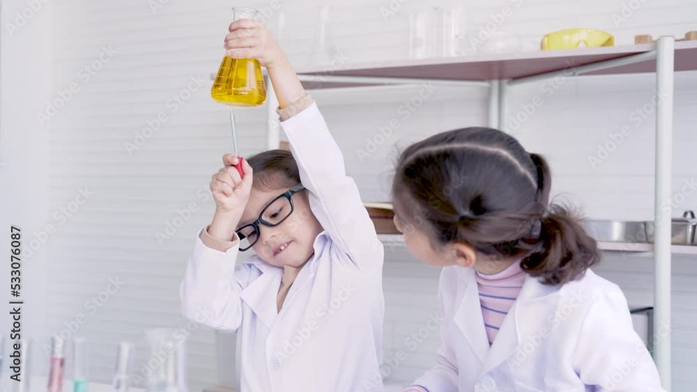 4K, Adorable youngsters in lab suits in school science room having fun ...