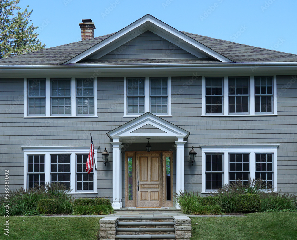 Front of traditional two story suburban clapboard house with portico ...
