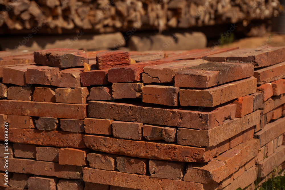 Red brick packed in stack are stored on ground outdoors at a hardware ...