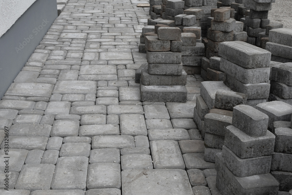 Laying gray concrete paving slabs in a house walkway. Process of ...