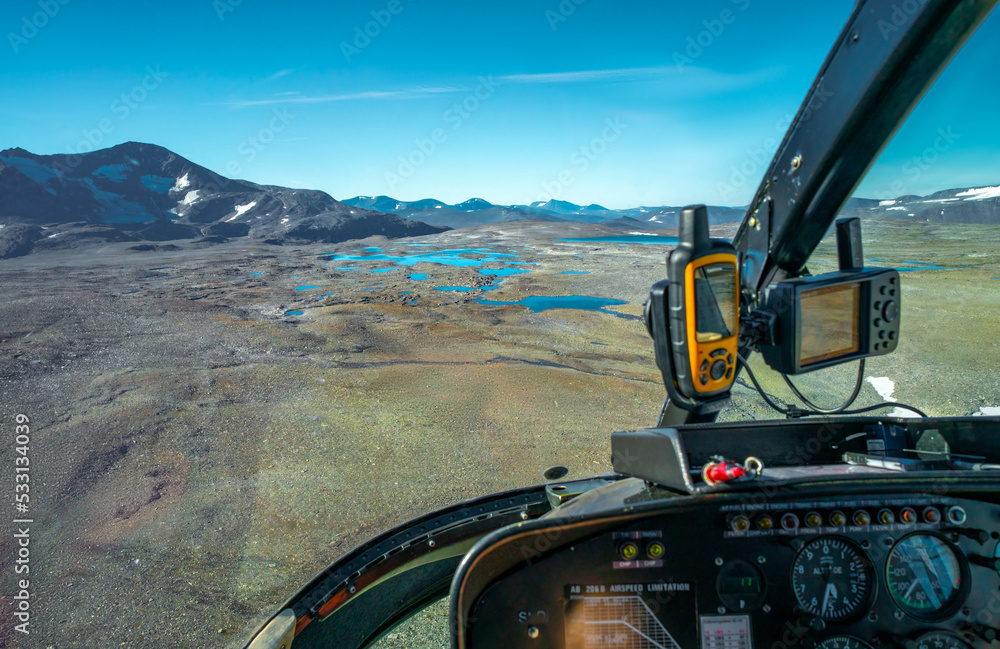 View from cockpit of small helicopter on lakes and mountains in vast ...