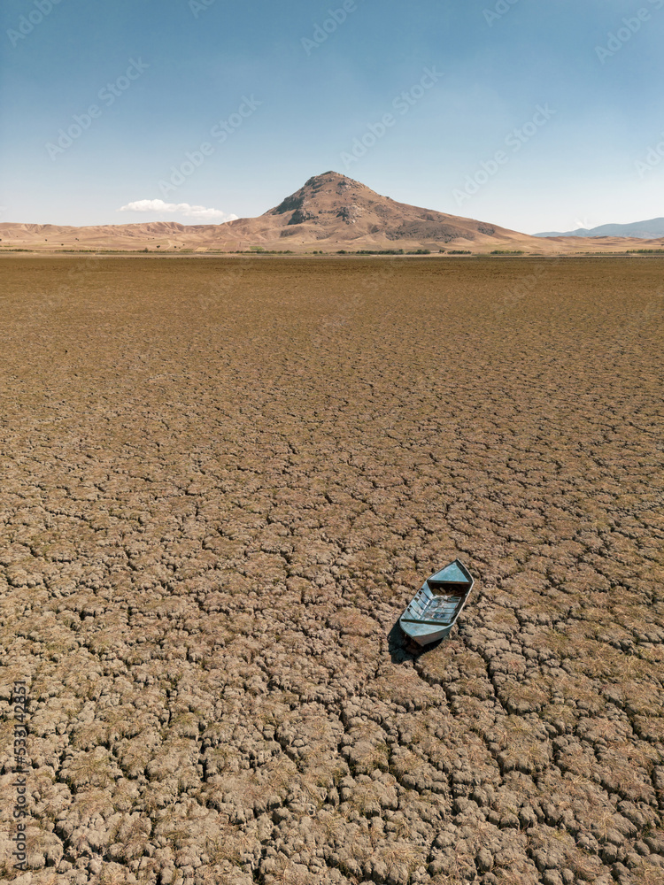 Abandoned row boat on cracked soil on lake bed dried up due to global warming and drought Stock ...
