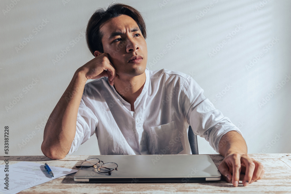 confused asian man overthinking sitting alone. despair indoors home ...