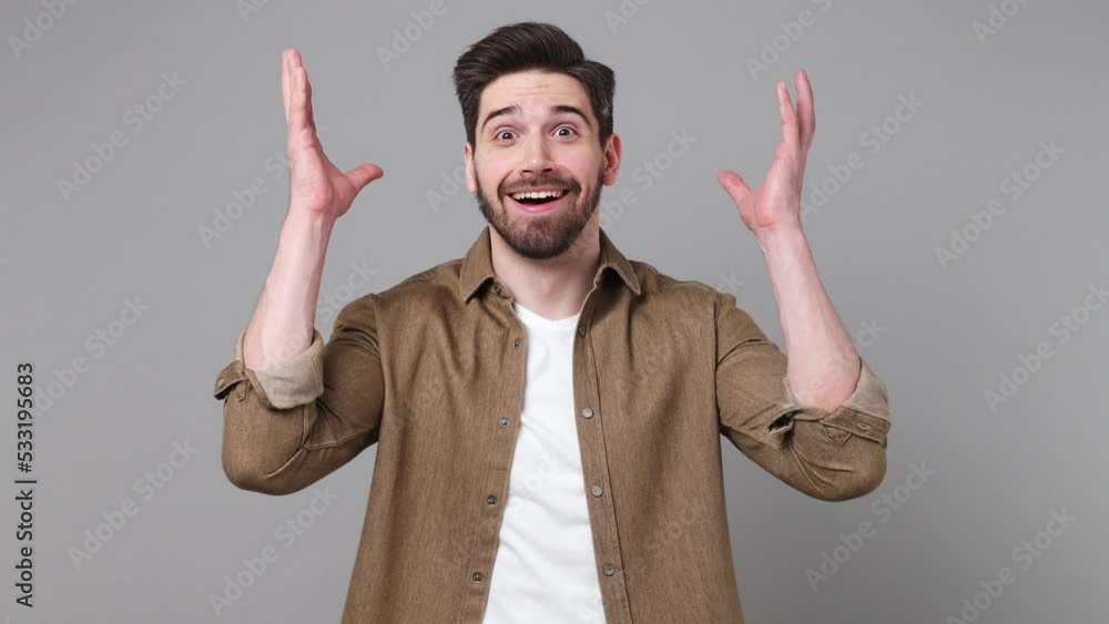 Young happy fun caucasian man 20s he wear brown shirt looking shocked ...