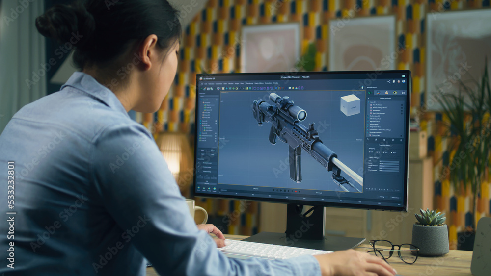 Female 3D designer creating 3D model of gun and making graphic using ...