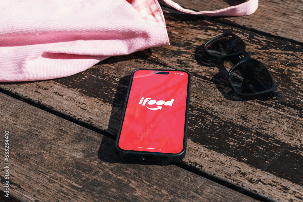 Ifood delivery app on the smartphone iPhone 14 Pro screen on the rustic ...