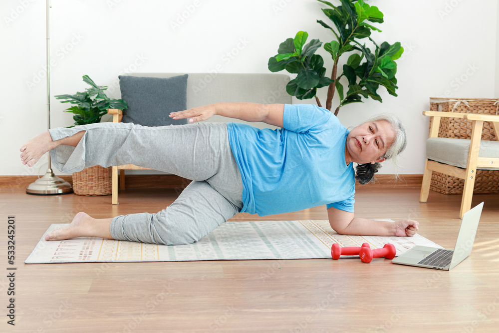 Asian elderly woman sitting at home exercising, doing exercises ...