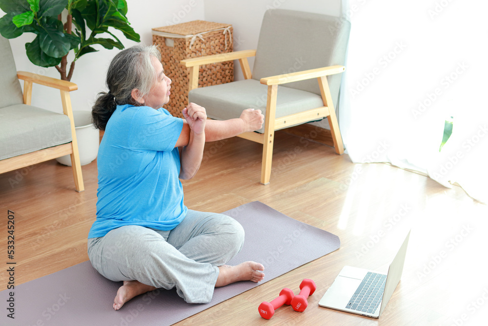 Foto de Asian elderly woman sitting at home exercising, doing exercises ...