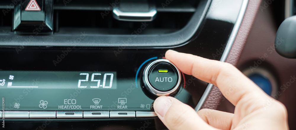 Woman hand adjusting temperature the air flowing during driving car on ...