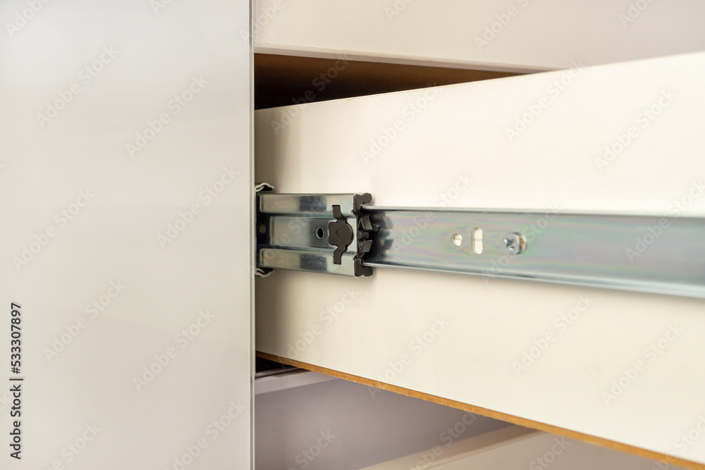 Roller stainless guide or rail for drawers with a closer. Close-up on a ...