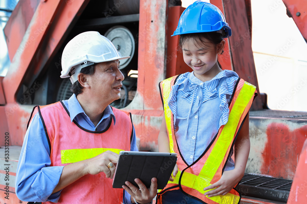Asian foreman father and his daughter sitting on forklift while ...