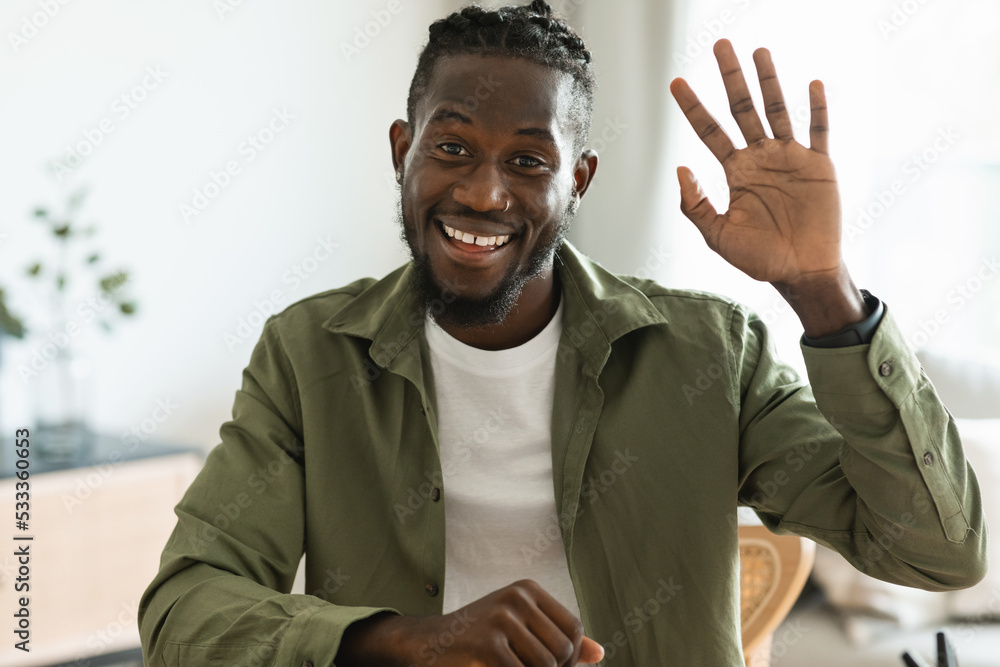 Greeting concept. Friendly black man waving at camera and smiling ...