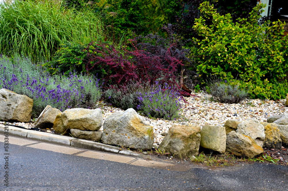 sandstone walls and stones in a flowerbed in a terraced terrain with ...